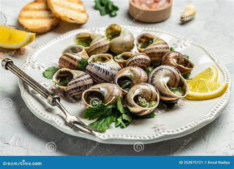 Delicious Cooked Sea Escargo Snails With Herbs Butter Garlic On Metal