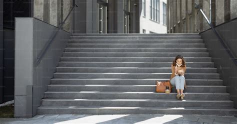 예쁜 여자는 계단에 앉아 사무실 건물 근처에서 야외 점심을 먹는다 테이크 아웃을위한 건강한 식사 턱에 보호 마스크를 내리고 사회적 거리를 두고 공간을 복사합니다 사진