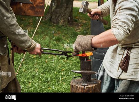 Work of a medieval blacksmith for the manufacture of metal products. Reconstruction of the ...