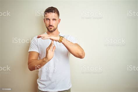 젊은 잘 생긴 남자 입고 캐주얼 흰색 티셔츠 위에 고립 된 배경 수행 시간 아웃 제스처 와 손 좌절과 심각한 얼굴 T 셔츠에 대한 스톡 사진 및 기타 이미지 Istock