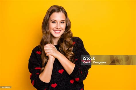 예쁜 매력적인 물결 모양의 아가씨가 손바닥을 들고 사랑스러운 시계 깜짝 선물 에서 남자 친구 착용 하트 패턴 스웨터 고립 된 노란색 색상 배경의 사진 갈색 머리에 대한 스톡