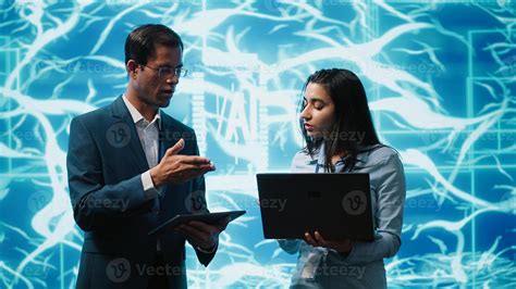 Coworkers Solving Tasks On Laptop And Tablet Running Artificial Intelligence Programming