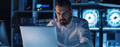 focused it engineer working late night in a data center using a laptop