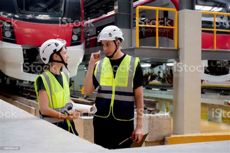 젊은 백인 엔지니어 남성과 여성이 만나 역 운송 및 기반 시설의 유지 보수를 계획하기 위해 전기 열차를 점검하고 검사관이