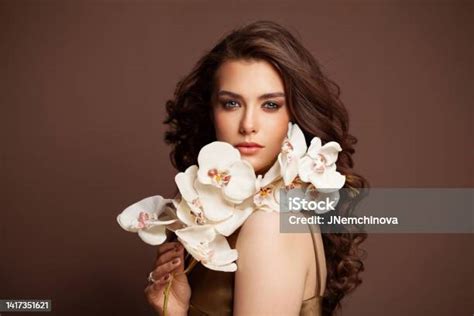하얀 꽃 초상화를 들고 아름다운 긴 물결 모양의 머리카락을 가진 화려한 여자 18 19세에 대한 스톡 사진 및 기타 이미지 18 19세 가발 갈색 Istock
