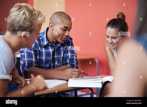 Putting Their Assignment Ideas On Paper A Group Of University Students Studying Together Stock