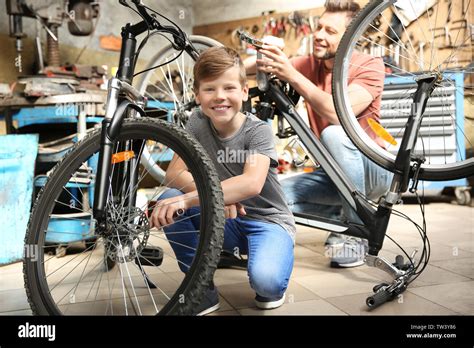 Dad And Son Fixing Bicycle In Garage Stock Photo Alamy