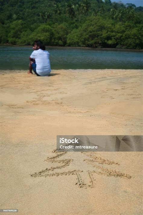 물가의 햇볕이 잘 드는 해변에 막대기로 모래에 그려진 크리스마스 트리 배경에 바다에 앉아 있는 인도 남자 전경에 초점을 맞추고 남반구 개념의 크리스마스 30 34세에 대한