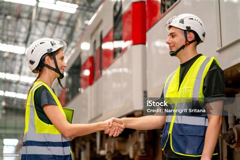 전문 엔지니어 또는 공장 기술자 노동자 남자와 여자는 철도의 전기 열차 근처의 직장에서 함께 합류 한 프로젝트의 성공을 위해