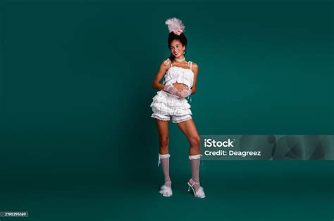 바로크 양식의 흰색 의상을 입은 여성이 녹색 배경을 배경으로 우아하게 포즈를 취하며 클래식과 모던한 패션이 조화를 이루고 있습니다 25 29세에 대한 스톡 사진 및 기타