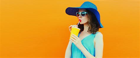 오렌지 배경에 여름 모자를 쓰고 컵에서 신선한 주스를 마시는 아름다운 젊은 여성의 초상화 광고 텍스트를위한 빈 복사 공간 드레스에 대한 스톡 사진 및 기타 이미지 Istock