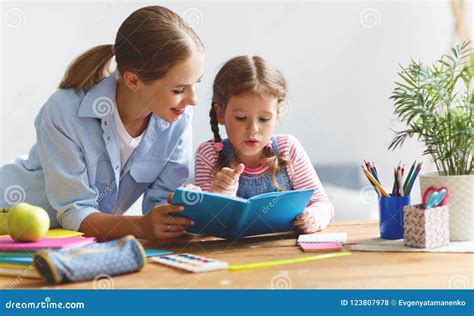 Κόρη μητέρων και παιδιών που κάνει την εργασία που γράφει και που διαβάζει Στοκ Εικόνες εικόνα