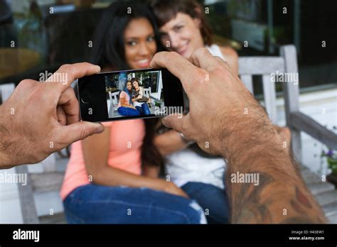 Man Photographing Women With Cell Phone Stock Photo Alamy