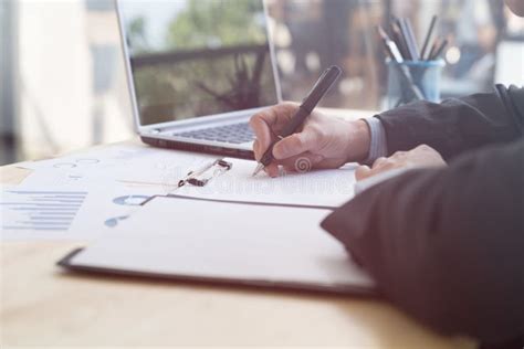 Businessman Analyzing Charts And Graphs And Taking Notes Stock Image