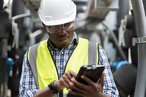 남성 배관공 엔지니어가 건설 현장의 하수관 구역에서 작업의 질을 검사하고 있다 건물 옥상에서 아프리카계 미국인 남성 엔지니어 작업자 점검 또는 유지 보수 하수관 네트워크