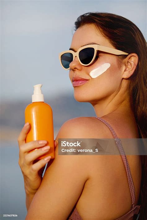 스킨 케어 컨셉 얼굴에 선크림을 바르는 아름 다운 젊은 여자 해변에서 자외선 차단제 병을 들고 있는 소녀 피부에 보습 로션을 바르는 여성 자외선 차단 선탠 30 34세에