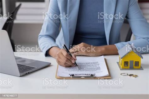 부동산 중개인 제시 및 서명 보험 양식 계약을 의사 결정에 고객에게 상담 구입 및 주택 모델을 판매 모기지 대출 제안에 관한 주택 보험 및 주택 보험 2명에 대한 스톡 사진
