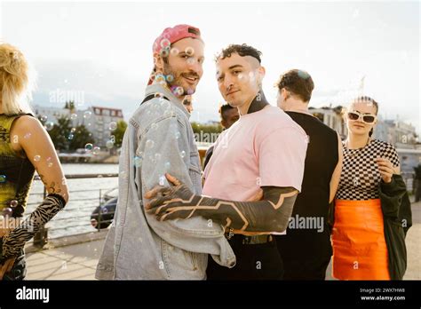 Side View Portrait Of Gay Man Standing With Non Binary Person On Promenade In City Stock Photo
