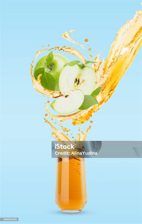 공중 부양 녹색 사과 잎 튀김 방울 파란색 배경이 있는 유리에 쏟아지는 사과 노란색 차가운 주스의 흐름 광고 디자인 전단지 카드 포스터를 위한 여름 알콜 음료 Green