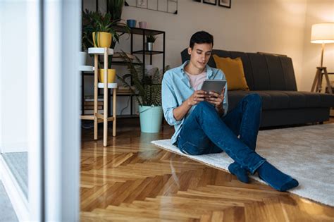 친환경 스마트 홈에서 모바일 앱을 사용하는 남자 남자는 모바일 응용 프로그램을 통해 바닥 난방을 제어 가을에 대한 스톡 사진 및