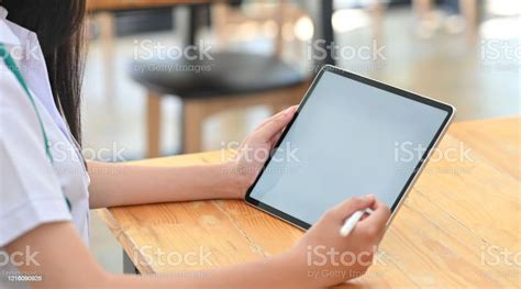 스타일러스 펜과 컴퓨터 태블릿을 들고 편안한 거실을 배경으로 작업 실에서 그림 스케치하는 동안 아름다운 여성 손의 자른 이미지