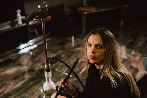 사용자 지정 V8 자동차 엔진 테이블 럭셔리 인테리어에 젊은 백인 금발 여자 흡연 뱃 가죽 소파와 아름 다운 미소 V8에 대한