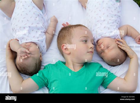 Caring Brother Holding His Twin Sisters With Love Close Up Stock Photo Alamy