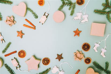 전나무 가지의 최고 보기 크리스마스 프레임 환경 친화적 인 골판지 선물 상자 나무 장난감 계피 밝은 녹색 배경에 말린 오렌지 제로 폐기물 플라스틱 선물 포장 없음 플랫레이