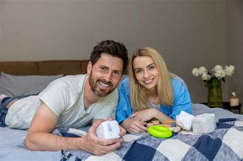 Cute Young Couple On Bed In Bedroom Looking Happy And Pleased Stock