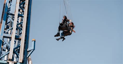 롤러코스터 위에서 짚라인을 타고 있는 남자 사진 Unsplash의 유원지 이미지