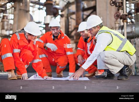 Workers With Blueprints At Oil Refinery Stock Photo Alamy