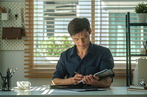 밀레니얼 세대의 사업가가 현대 직장에 앉아 근무 일정 계획을 확인하고 있다 학습에 대한 스톡 사진 및 기타 이미지 학습