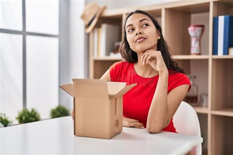 Young Brazilian Woman Looking Inside Cardboard Box Smiling Looking