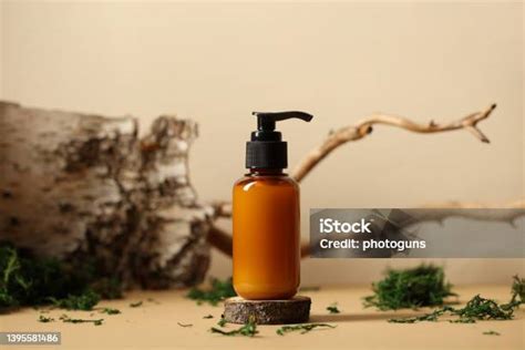 자작 나무 나무 가지 녹색 이끼의 껍질이있는 호박색 유리 펌프 화장품 병 천연 유기농 미용 제품 포장 디자인 강단에 대한 스톡