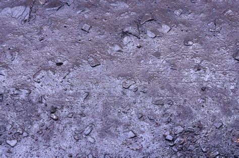 Close Up Of Muddy Puddle With Small Stones On Wet Surface Background Texture With Top View