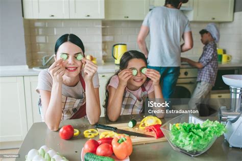 재미 있는 소녀는 음식과 놀고 있습니다 그들은 Etes가 있는 오이의 둥근 조각을 보유 하 고 미소 여자는 휴식을가지고 있다 Biys는 난로에서 일하고 있습니다 그들은