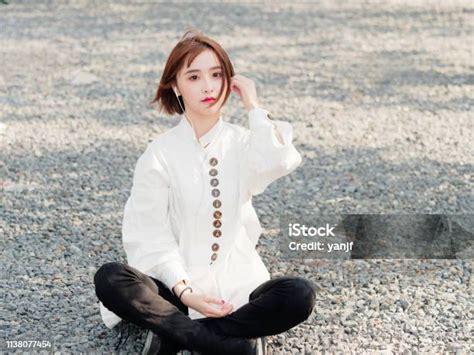 흰색 셔츠에 아름 다운 젊은 갈색 머리 여자 앉아서 화창한 날에 음악을 즐길 수 있습니다 매력적인 중국 쾌활 한 세련 된 여자의 야외 패션 초상화 감정 사람 아름다움과