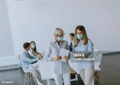 사무실에서 말하고 바이러스 보호로 마스크를 착용하는 두 명의 사업가 사람들에 대한 스톡 사진 및 기타 이미지 사람들 코로나바이러스 페이셜 마스크 Istock