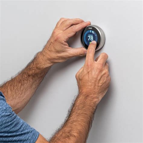 Smart Thermostat On Wall Being Adjusted By Man With Hairy Arms Showing