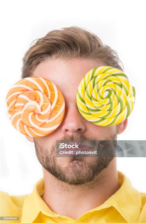 안경으로 눈에 최면 패턴을 가진 큰 롤리팝을 가진 남자 최면 개념 흰색 배경에 고립 된 거대한 다채로운 롤리팝과 차분한 얼굴에