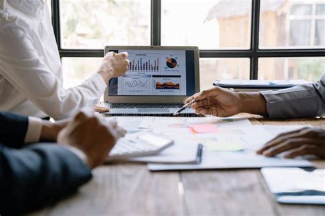 Businessmen Team Or Financial Data Analysts Working With Tablets And Laptop Computers And Data