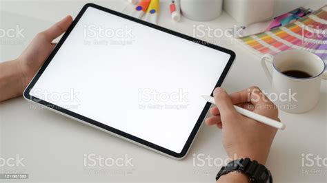 스타일러스 펜과 디자이너 용품이 있는 모형 태블릿에서 작업하는 디자이너의 크롭 샷 개념에 대한 스톡 사진 및 기타 이미지