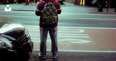검은 재킷과 파란색 데님 청바지를 입은 남자가 낮 동안 보행자 차선에 서 있다 사진 Unsplash의 무료 사람의 이미지