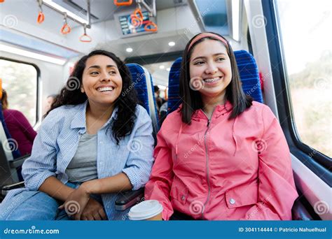 Two Young Latin Women Passenger Friends Traveling On Public Train