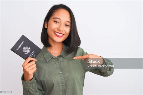 아름다운 중국 여자 들고 미국 미국 여권 위에 고립 된 흰색 배경 와 깜짝 얼굴 가리키는 손가락 에 자신 가리키기에 대한 스톡 사진 및 기타 이미지 Istock