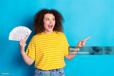 매력적인 젊은 여자의 사진 돈 부채 보기 포인트 빈 공간 옷을 입은 줄무늬 노란색 옷 파란색 배경에 고립 된 가리키기에 대한 스톡 사진 및 기타 이미지 Istock