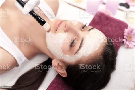 닥터 뷰티 살롱에서 젊은 여자의 얼굴에 막대기로 마스크를 적용 하는 클렌징과 피부 보습의 절차에 대 한 미용사입니다 미용 하 고
