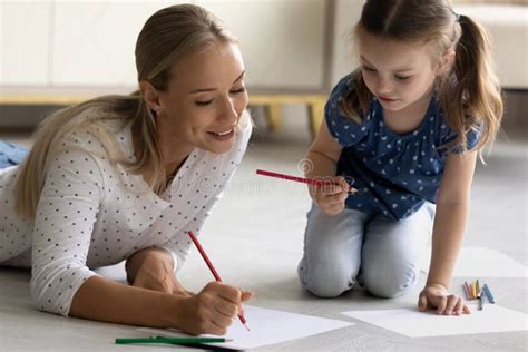Mamma Felice Che Insegna Alla Bambina Un Disegno Immagine Stock