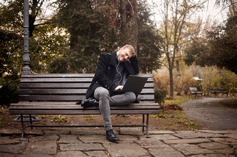 한 영 웃 고 행복 한 사람 공공 공원에서 벤치에 앉아 컴퓨터를 보고 노트북을 사용 하 여 공식적인 마모 또는 스마트 캐주얼입니다 전체 길이 총 20 24세에 대한 스톡