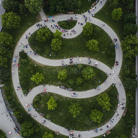Aerial View Of Serpentine Park Paths Lush Green Landscape With People